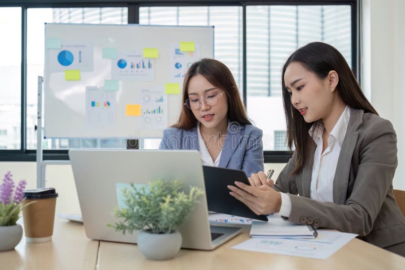 Two Young Accountant Collaborating on Financial Reports in a Modern ...