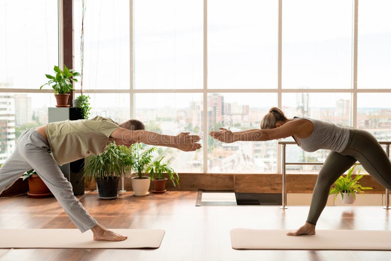 Two Young Active Dates Bending Forwards while Exercising in Front of ...