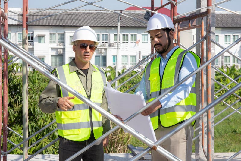 Two Young Architect Discussion or Contractor Man while Looking ...