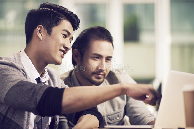 Two Young Asian Business Men Working Together in Office Using Laptop ...