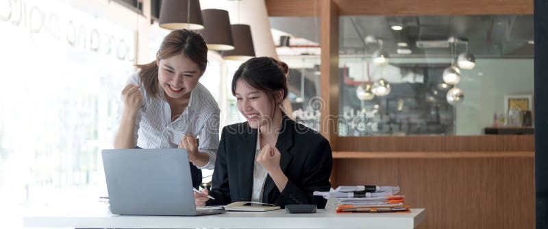 Two Young Asian Businesswomen Show Joyful Expression Of Success At Work