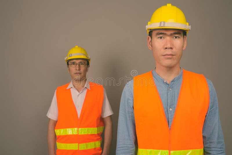 Two Young Asian Men Construction Worker Together Against Gray Ba Stock ...