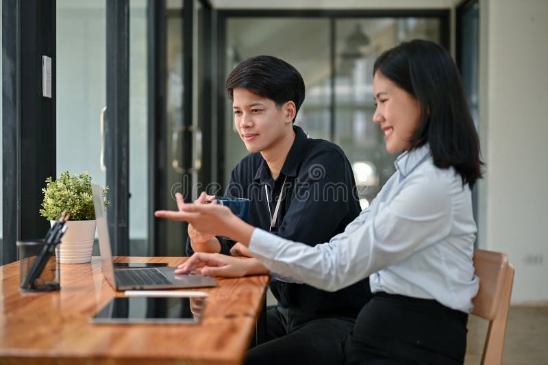 Two Young Asian Office Workers are Working Remotely at a Coffee Shop ...