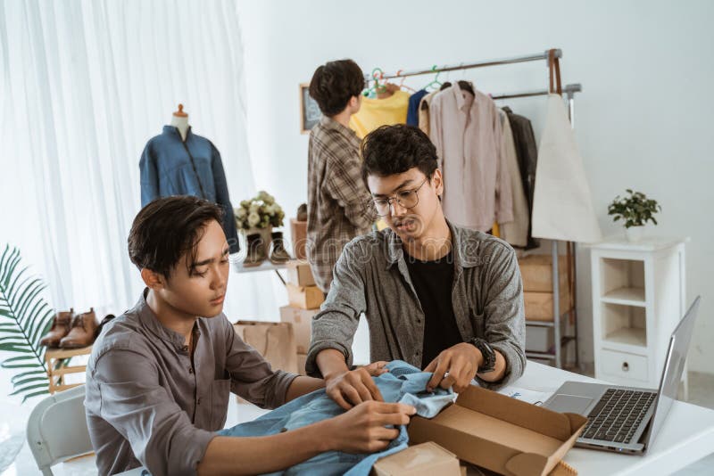 Two Young Asian Workers Work Together To Pack Clothes Stock Photo ...