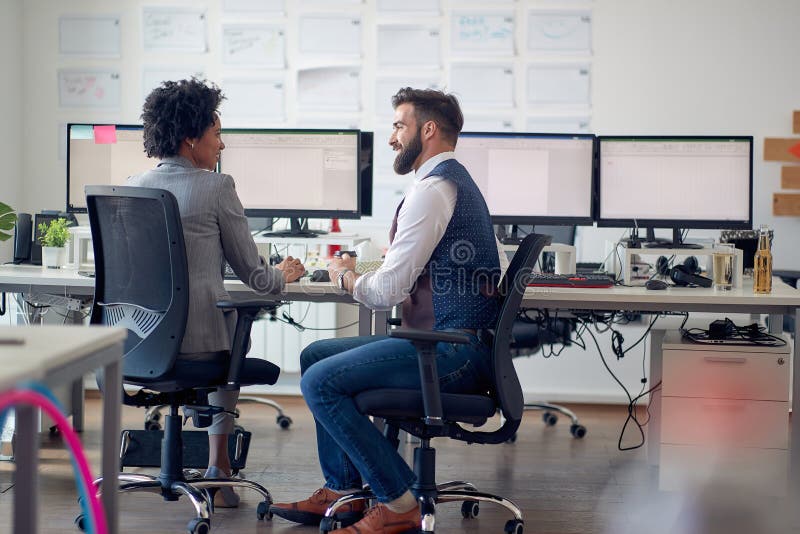 Two Young Attractive Coworkers Discussing Together Stock Photo - Image ...