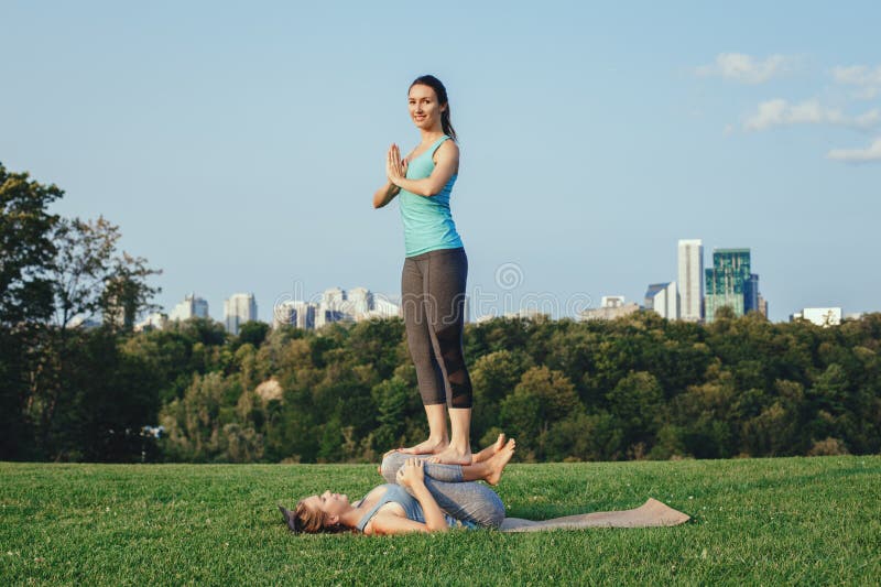 Two Caucasian Women Doing Yoga Stretching Workout In Park Outdoors At
