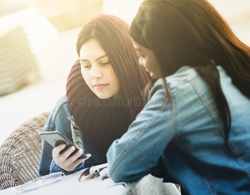 Two Friends Talking and Using the Mobile Phone Stock Image - Image of ...