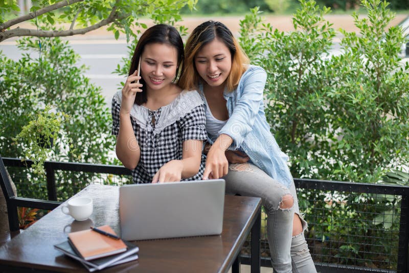 Two Young Beautiful Women Searching Information at Laptop Computer in ...