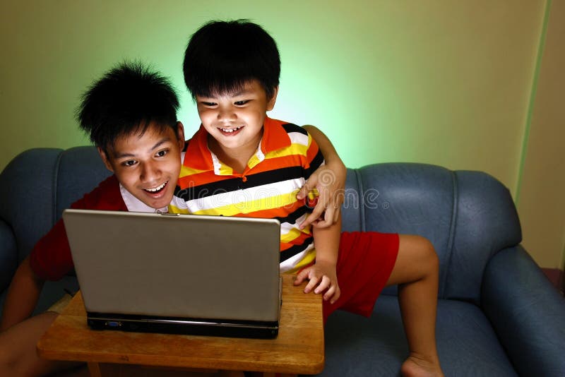 Two Young Boys Using a Laptop Computer and Smiling Stock Photo - Image ...