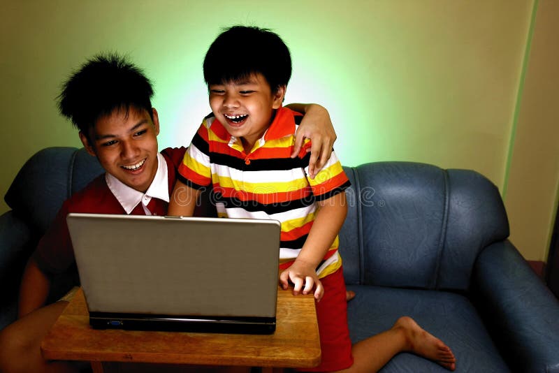Two Young Boys Using a Laptop Computer and Smiling Stock Photo - Image ...
