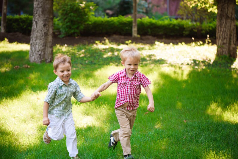 Two Young Boys Walk and Relax in the Park. Stock Image - Image of field ...