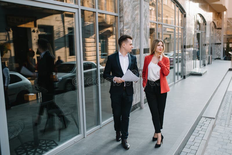 A Two Young Business-people are Walking Along Office Building Stock ...