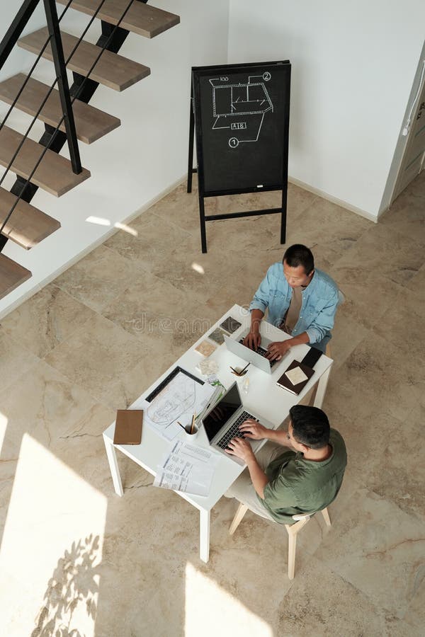 Two Young Busy Office Workers Sitting by Table and Typing Stock Image ...