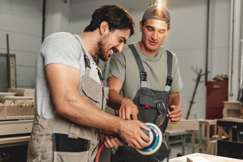 Two Young Carpenters Working with Wood Standing at Table in Workshop ...