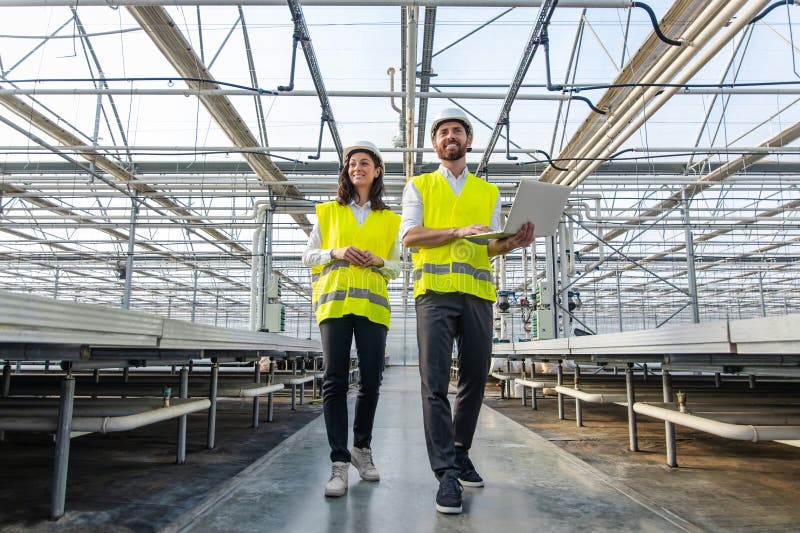 Two Young Caucasian Engineers Inspecting a Greenhouse Construction Site ...