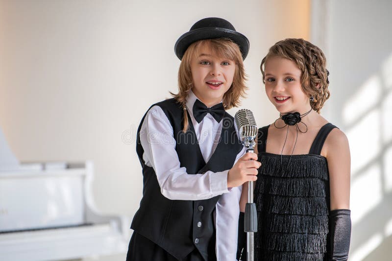 Two Young Children in Formal Wear Sing a Duet into a Microphone. Stock ...