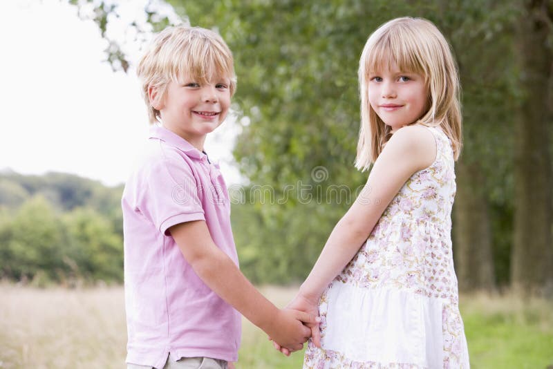Two Young Children Standing Outdoors Holding Hands Stock Photo - Image ...