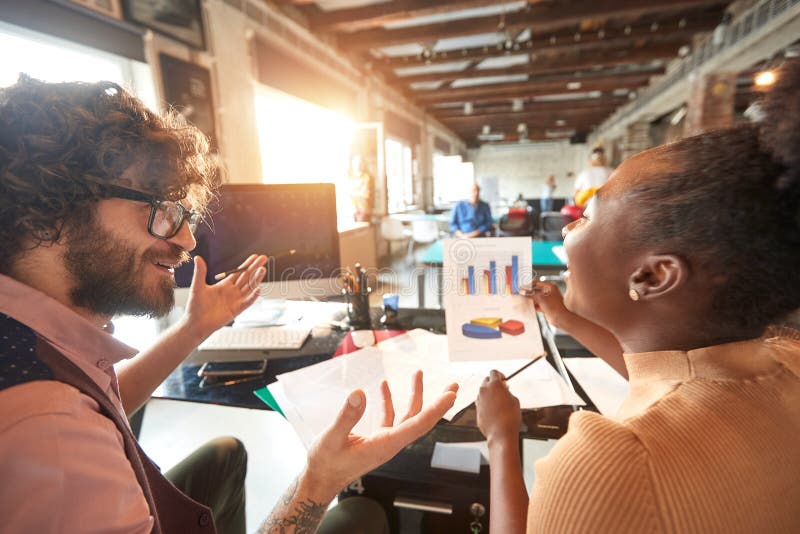 Two Young Colleagues are Having a Good Time at Office while Working on ...