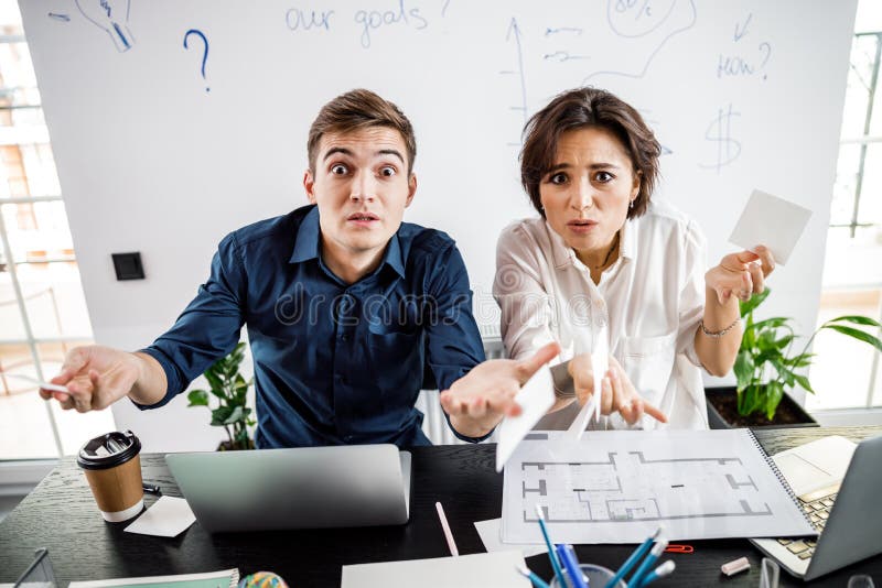 Two Young Colleagues Looking at Camera with Misunderstanding Stock ...