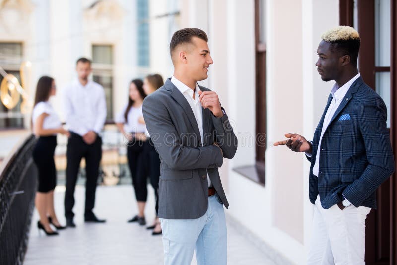 Two Young Colleagues Looking Discussing in Front Their Business Team ...