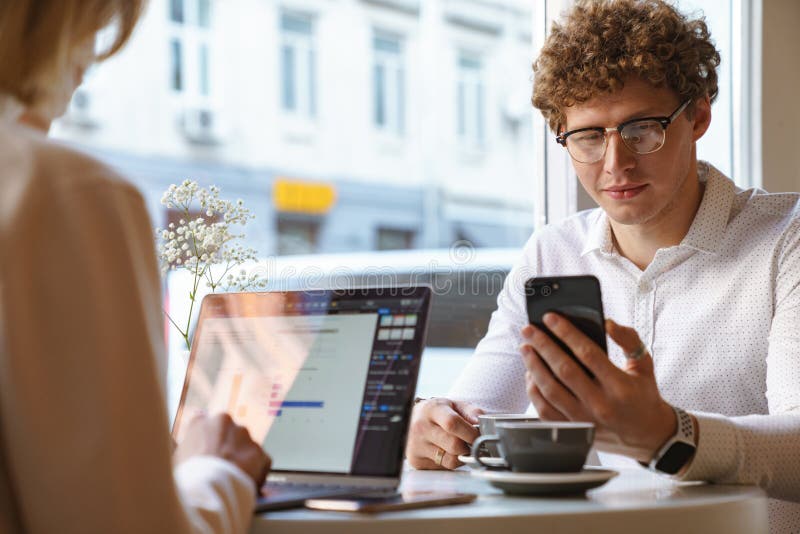 Two Young Colleagues Working Together while Having Lunch Break Stock ...