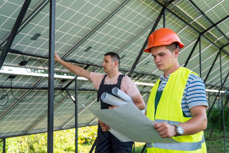 Two Young Courageous Workers in Uniform Stand Under Solar Panels Stock ...