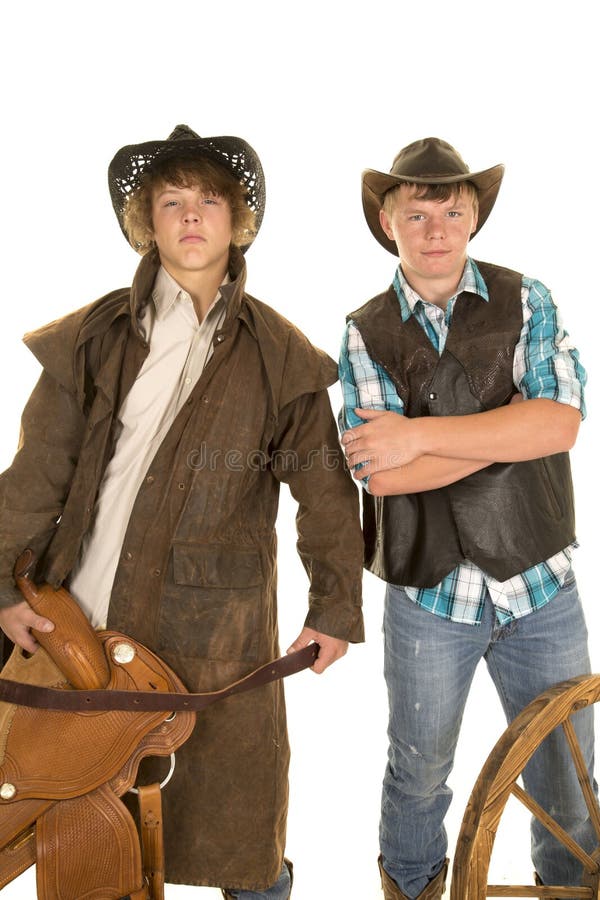 Two Young Cowboys with Saddle and Wagon Wheel Stock Photo - Image of ...