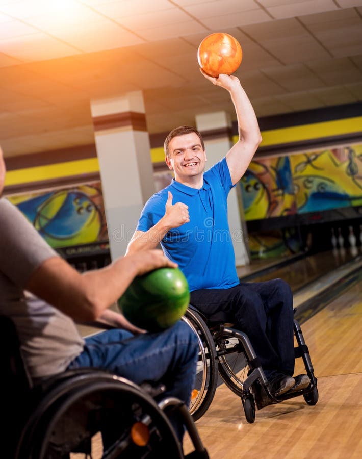 Two Young Disabled Men In Wheelchairs Playing Bowling In The Club Stock ...