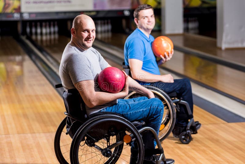 Two Young Disabled Men in Wheelchairs Playing Bowling in the Club Stock ...