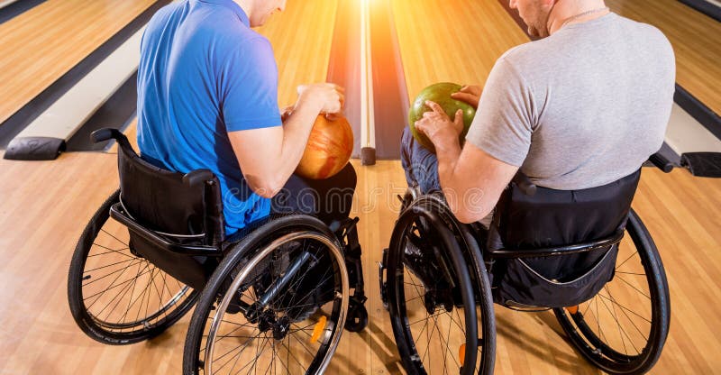 Two Young Disabled Men in Wheelchairs Playing Bowling in the Club Stock ...