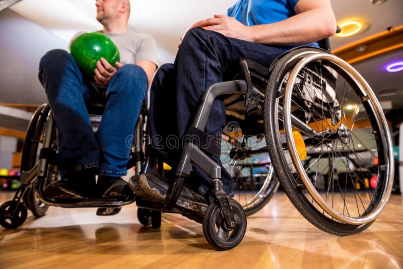 Two Young Disabled Men in Wheelchairs Playing Bowling in the Club Stock ...