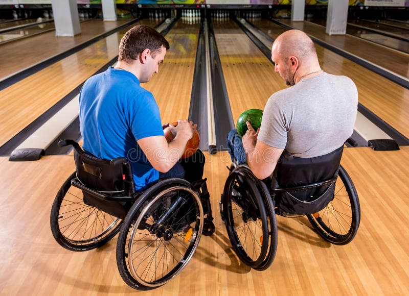 Two Young Disabled Men in Wheelchairs Playing Bowling in the Club Stock ...