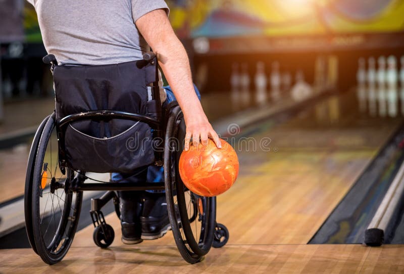Two Young Disabled Men in Wheelchairs Playing Bowling in the Club Stock ...