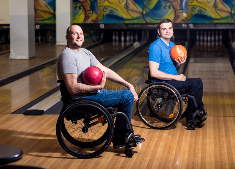 Two Young Disabled Men in Wheelchairs Playing Bowling in the Club Stock ...