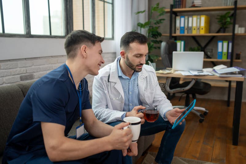 Two Young Doctors Having Tea and Surfing Internet Stock Photo - Image ...