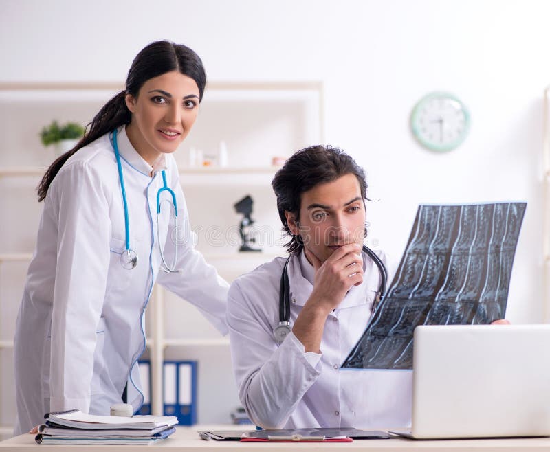 Two Young Doctors Working in the Clinic Stock Image - Image of illness ...