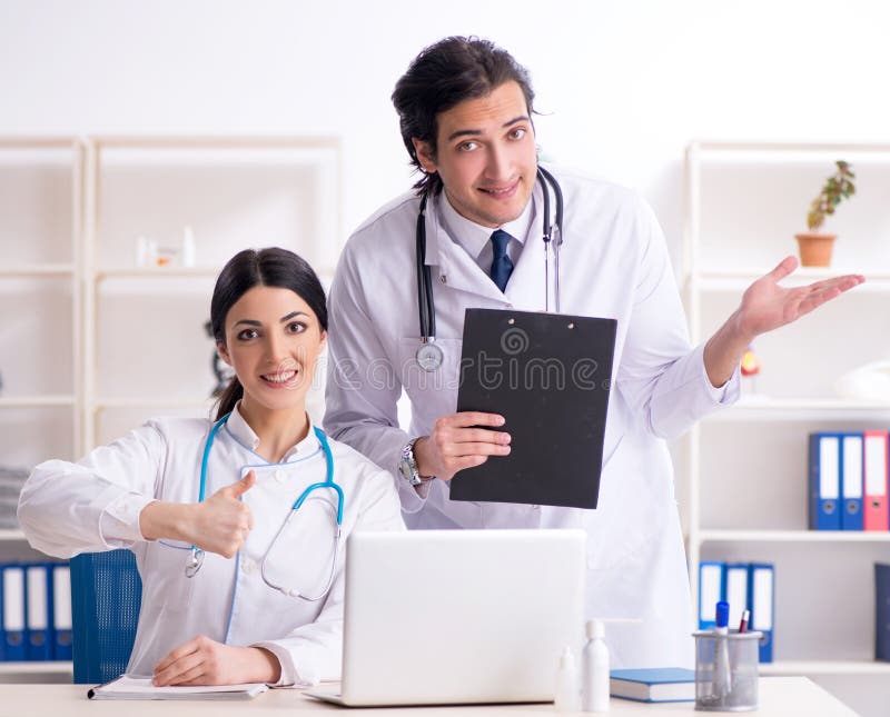 Two Young Doctors Working in the Clinic Stock Image - Image of illness ...