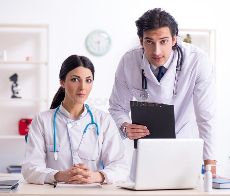 Two Young Doctors Working in the Clinic Stock Image - Image of happy ...