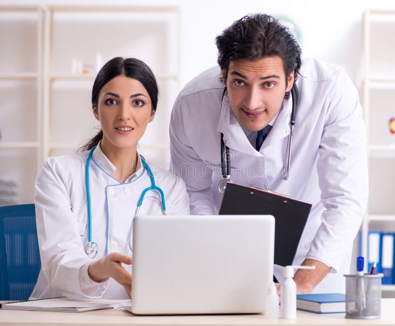 Two Young Doctors Working in the Clinic Stock Image - Image of laptop ...