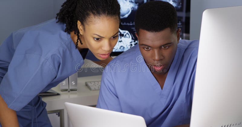 Two Young Doctors Working Together on Multiple Computers Stock Image ...