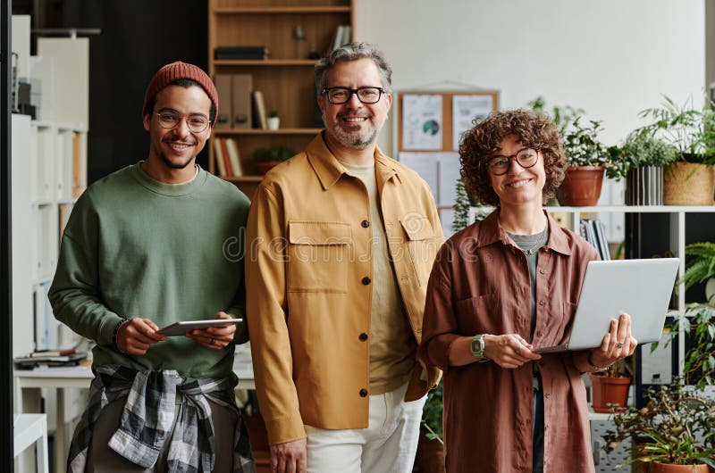 Two Young it Engineers with Gadgets Standing by Their Mature Boss Stock ...