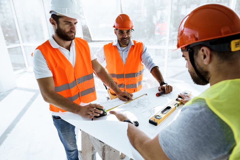Two Engineers Man Looking at Project Plan on the Table in Construction ...