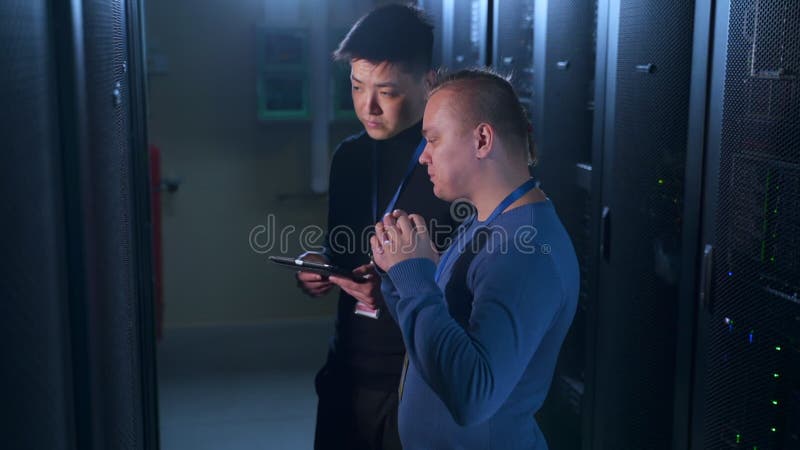 Two Young Engineers Talking and Doing Network Diagnostics in Workflow ...