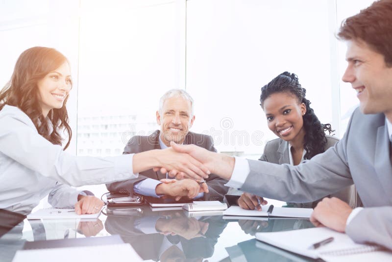 Two Young Executives Shaking Hands in Front of Their Director and a ...