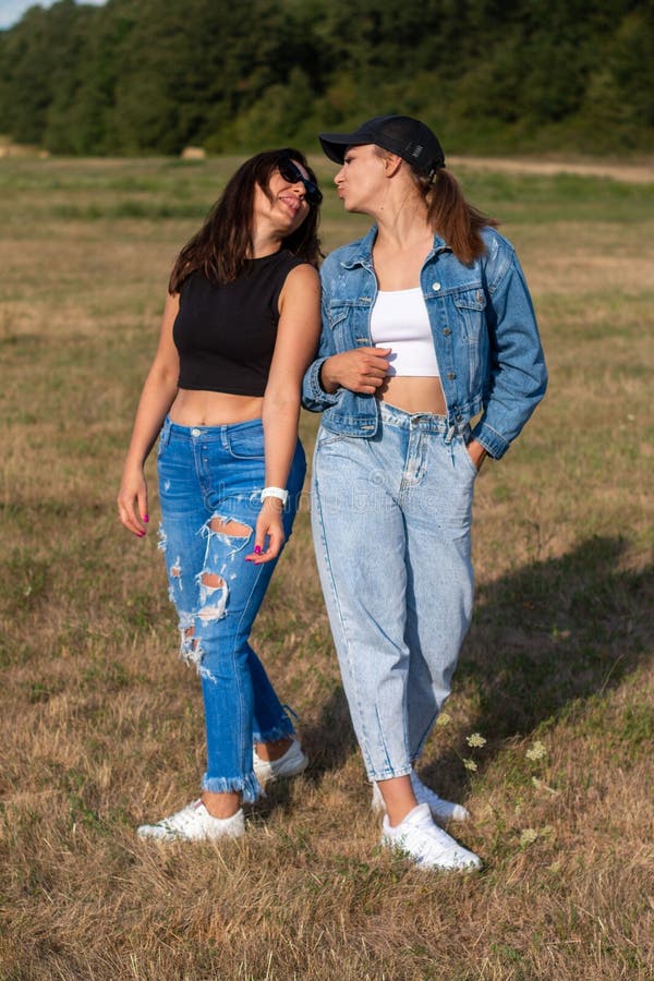 Young Female Friends Standing Outdoors in a Grassy Field Stock Photo ...