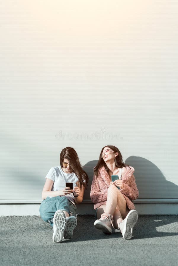 Two Young Female Friends Using Mobile Phones and Laughing Stock Image ...