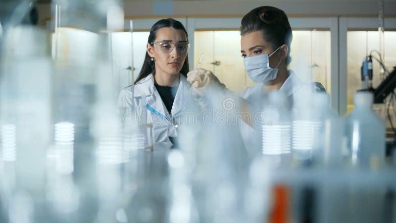 Two Young Female Scientist Doing Experiments in Lab Stock Footage ...
