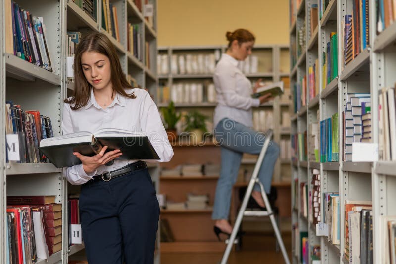 Two Young Female Students in a Public Library. Stock Image - Image of ...