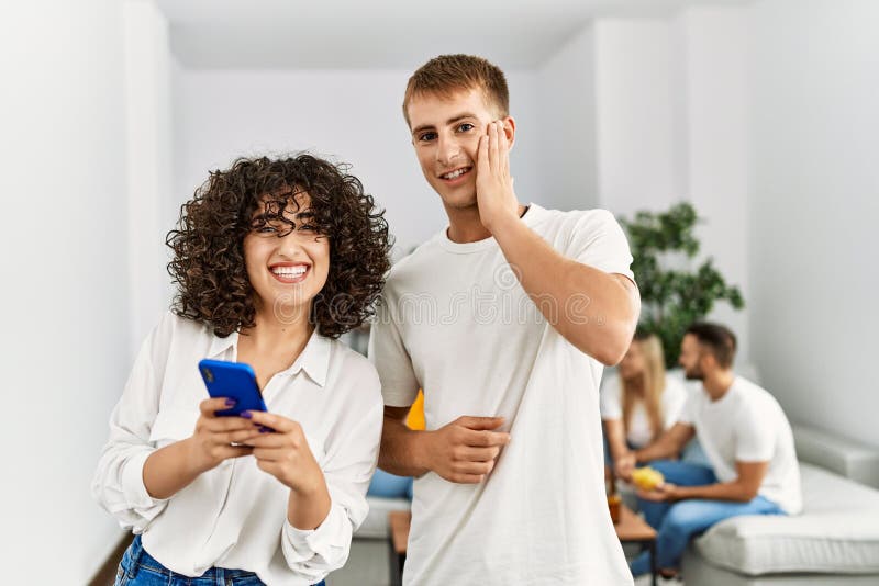 Two Young Friends Standing and Using Smartphone at Home Stock Image ...