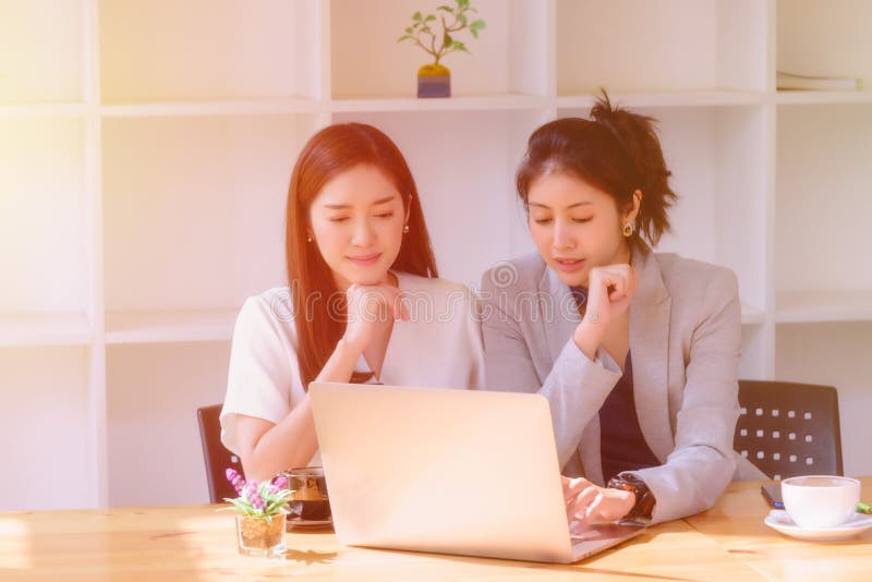 Two Young Girl Enjoy Working Using Laptop Computer on the Table Stock ...